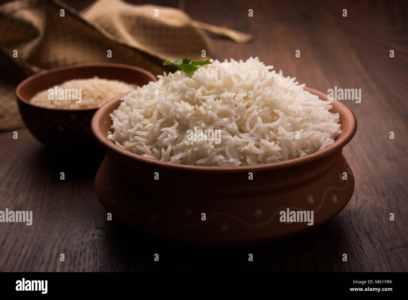 Cooked plain white basmati rice in terracotta bowl over plain or wooden ...