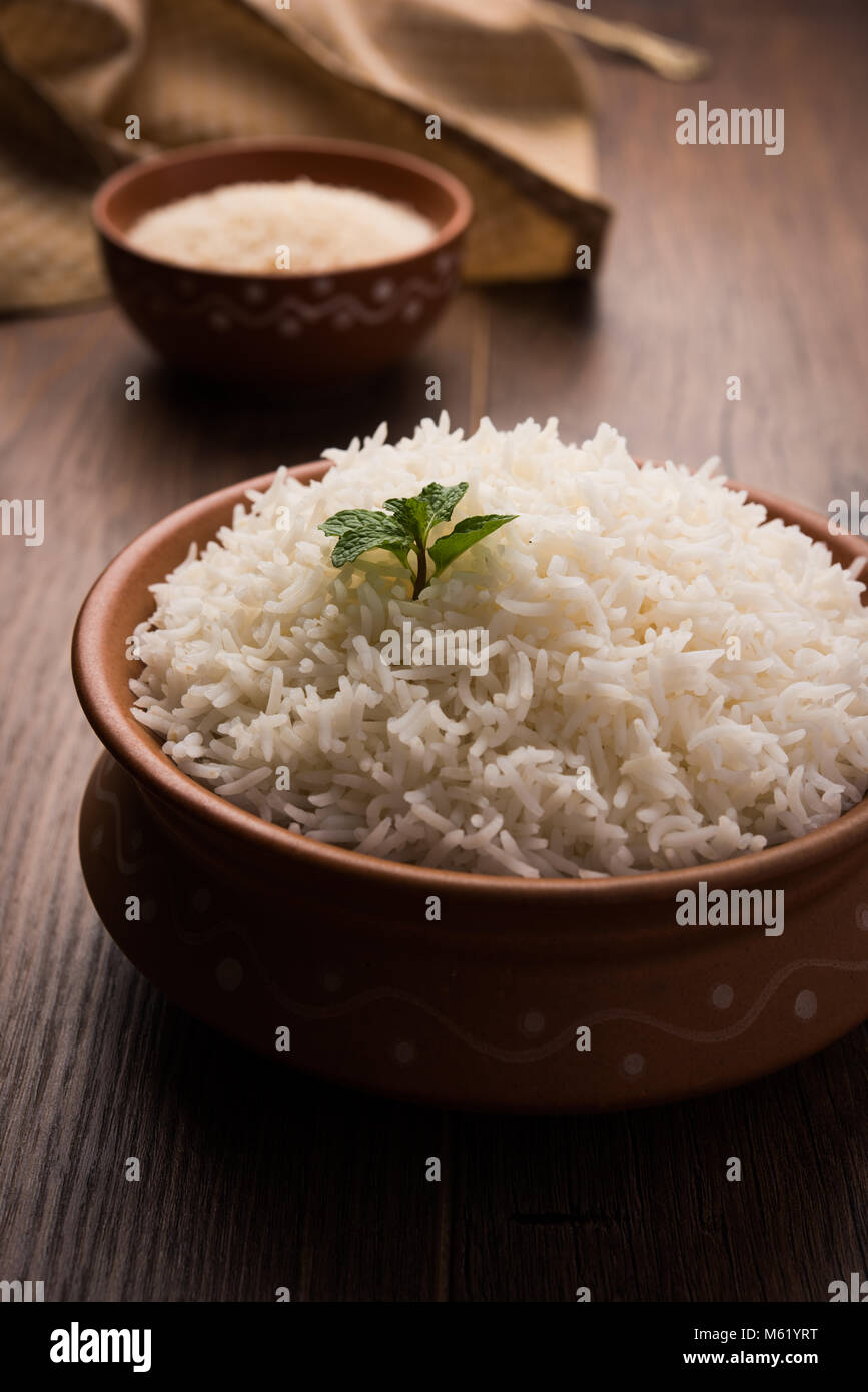Cooked plain white basmati rice in terracotta bowl over plain or wooden ...