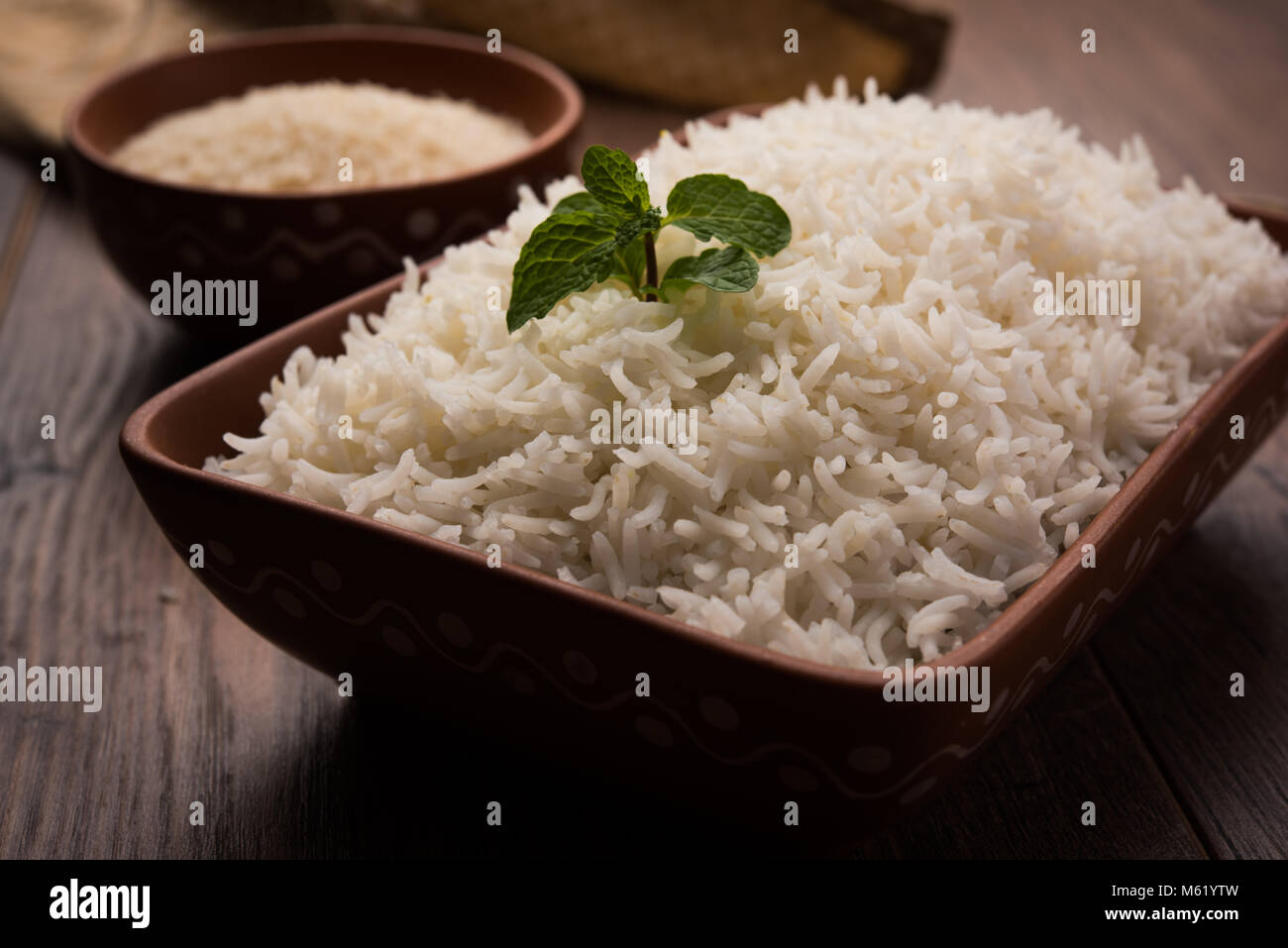 Cooked plain white basmati rice in terracotta bowl over plain or wooden ...