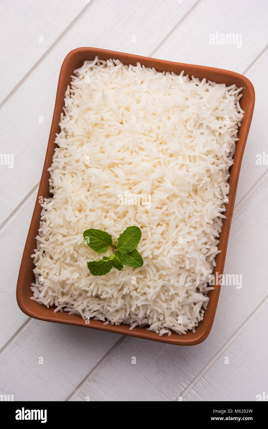 Cooked plain white basmati rice in terracotta bowl over plain or wooden ...