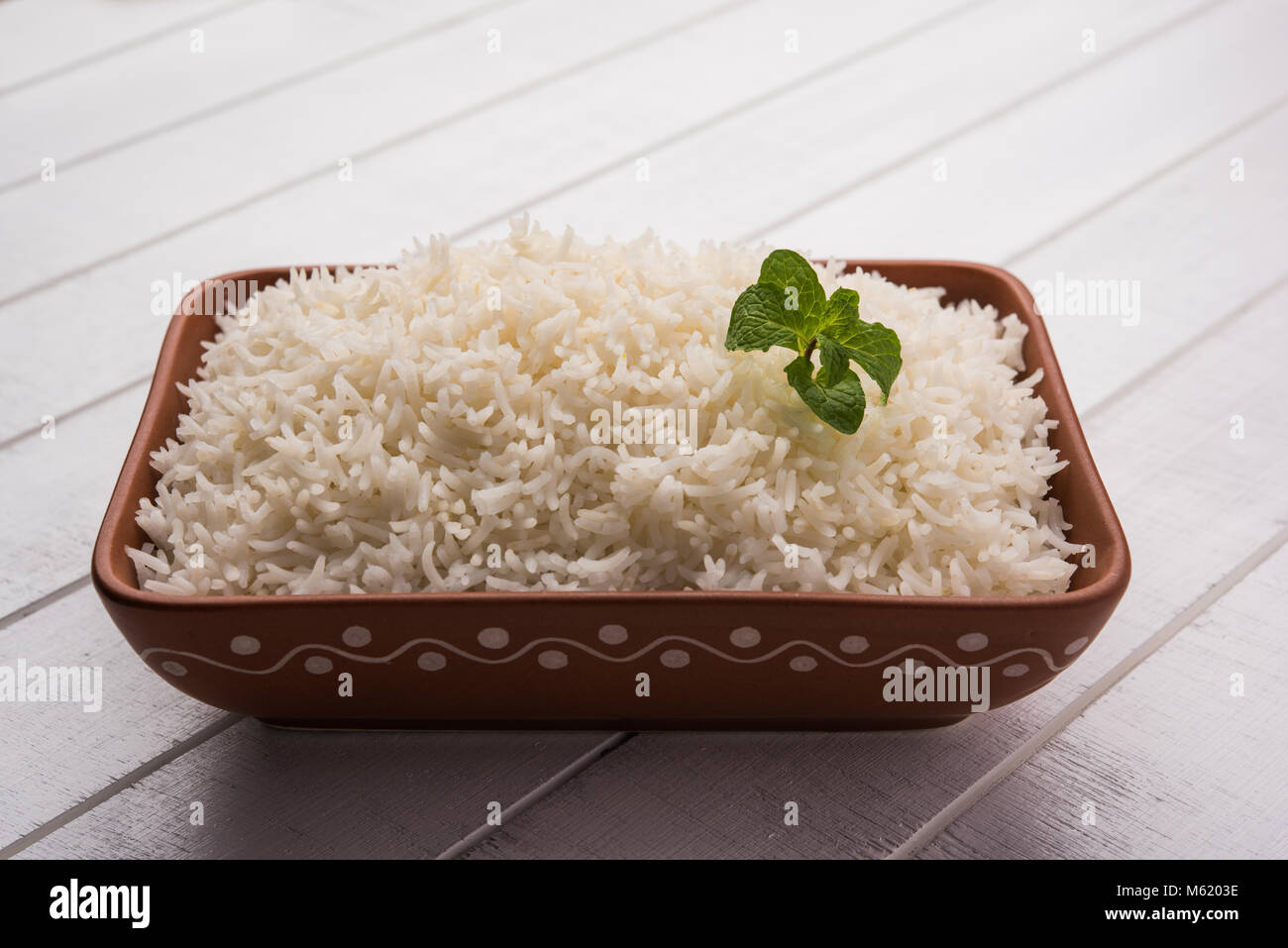 Cooked plain white basmati rice in terracotta bowl over plain or wooden ...