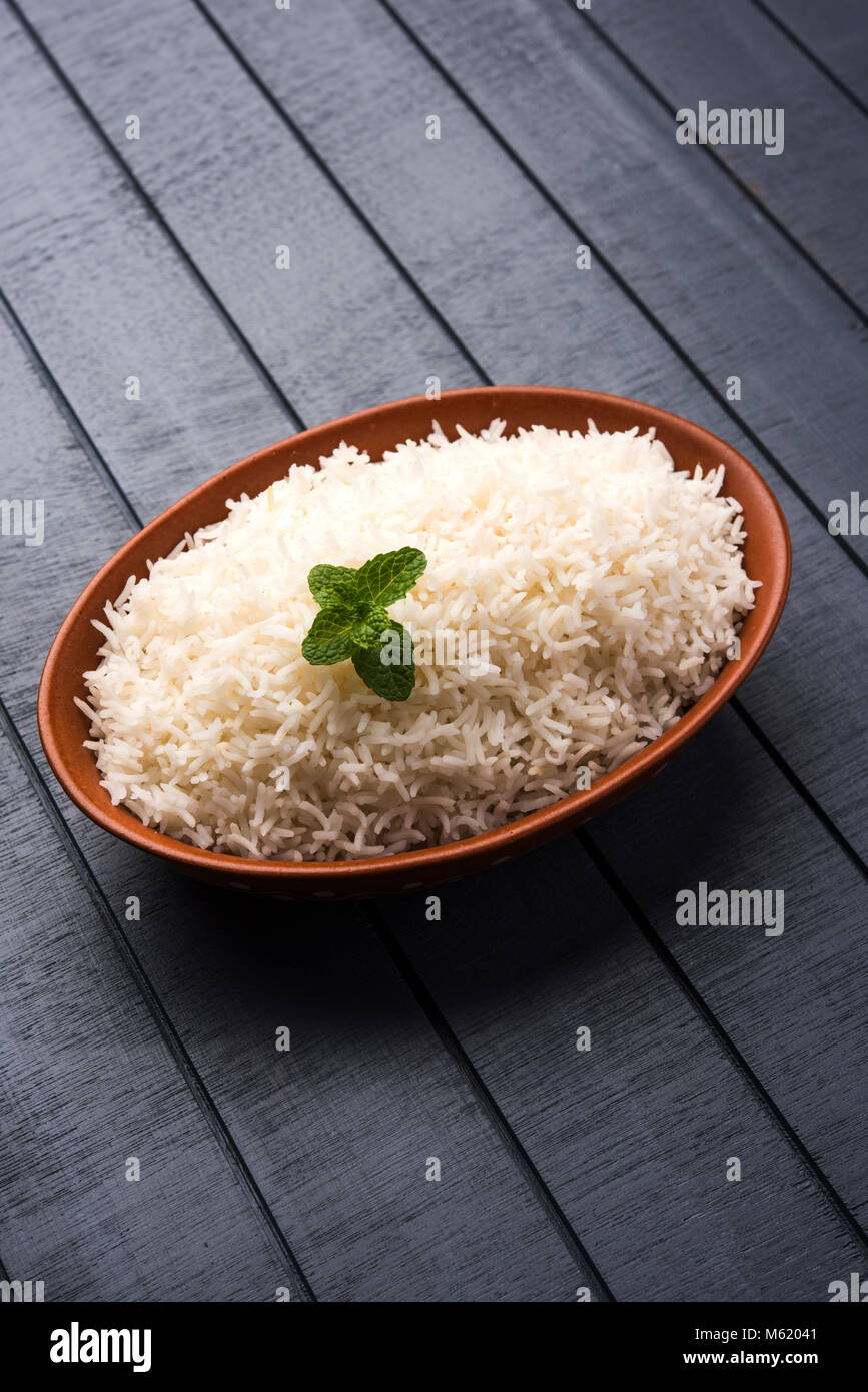 Cooked plain white basmati rice in terracotta bowl over plain or wooden ...