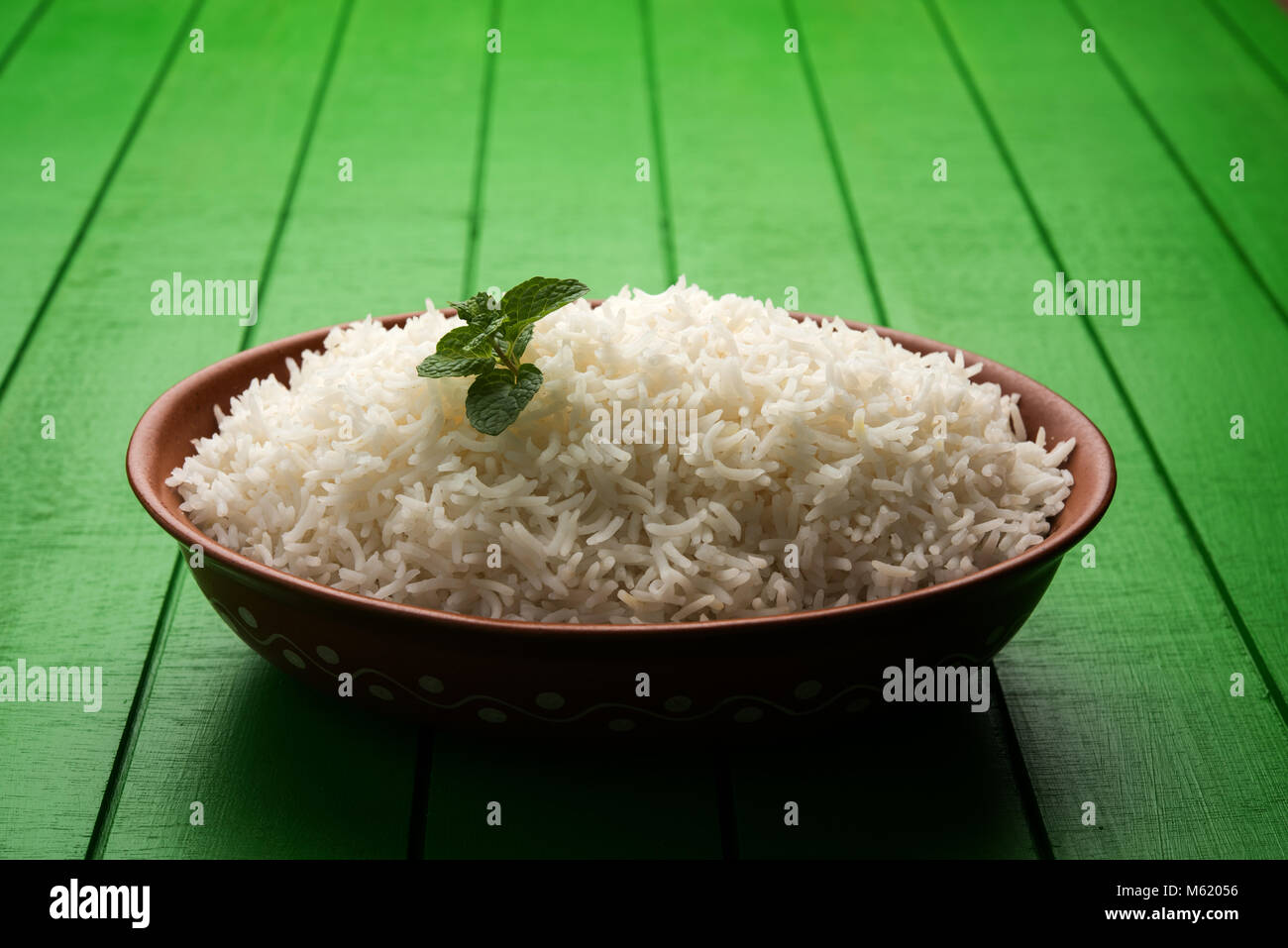Cooked plain white basmati rice in terracotta bowl over plain or wooden ...