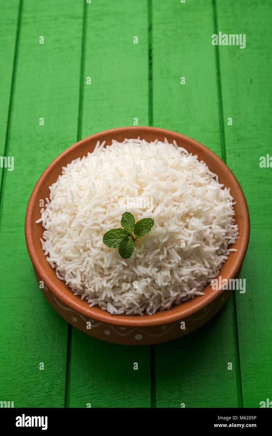 Cooked plain white basmati rice in terracotta bowl over plain or wooden ...