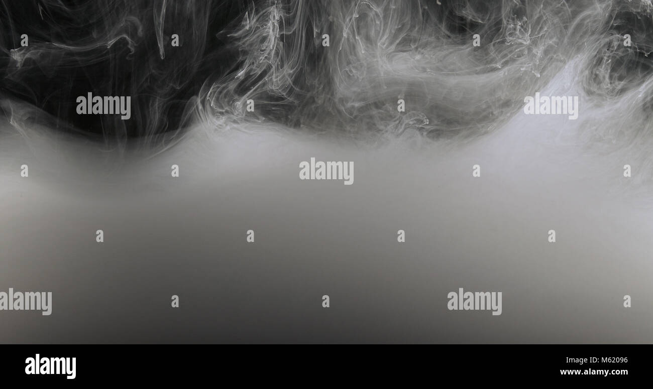 White drops, waves and clouds of ink creating dynamic shapes in water ...