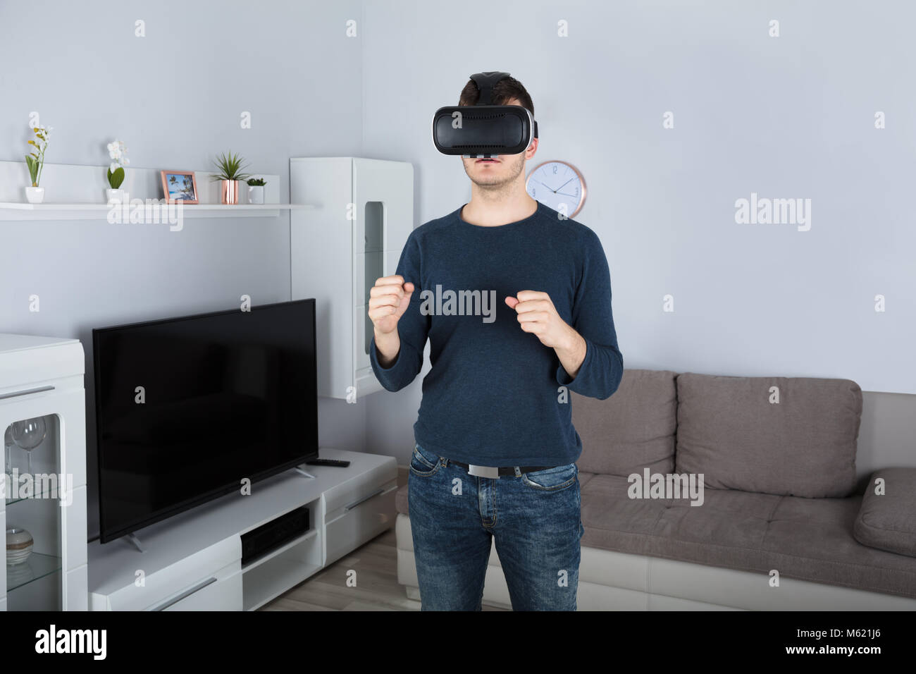 Portrait Of A Young Man Using Virtual Reality Headset With Hands Raised ...