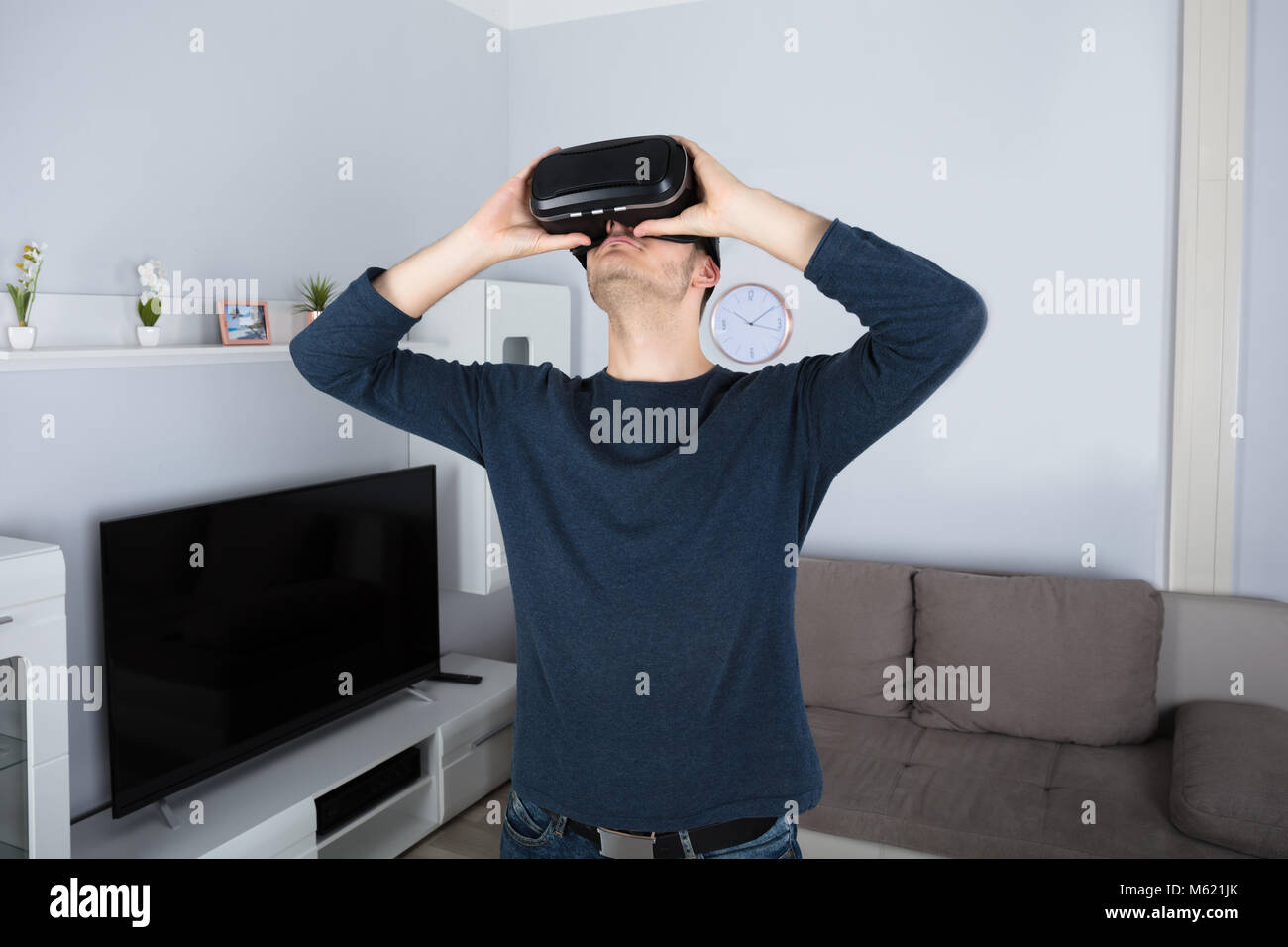 Portrait Of A Young Man Using Virtual Reality Headset With Hands Raised ...