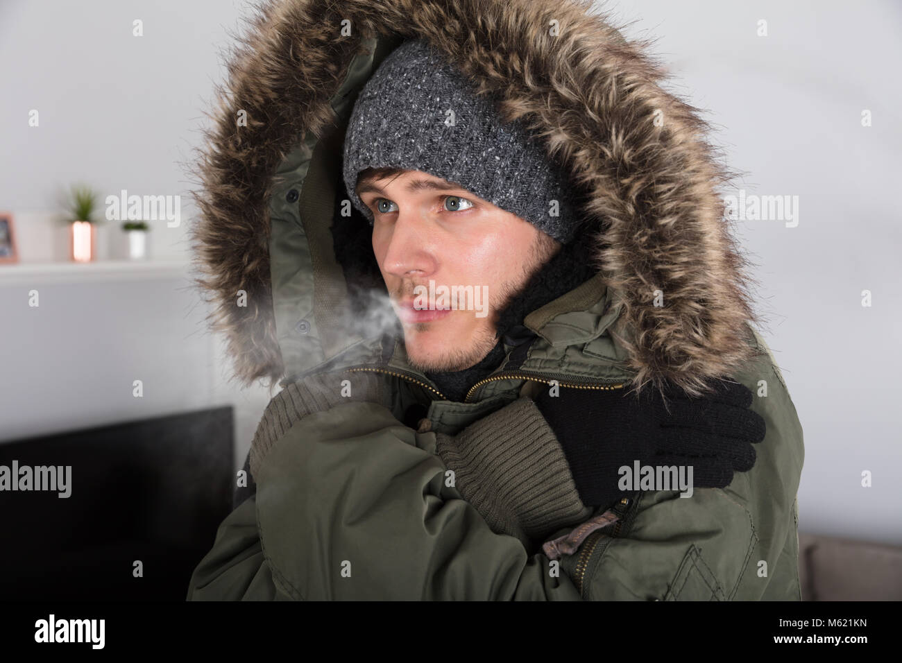 Young Man With Warm Clothing Feeling The Cold Inside House Stock Photo ...