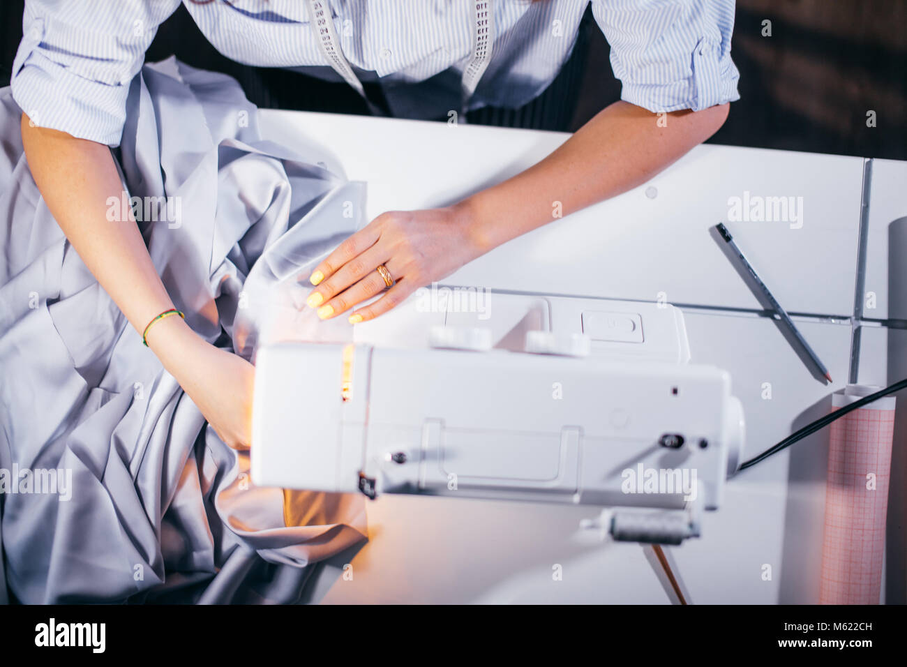 top view cropped photo of white working sewing machine with tailor's ...