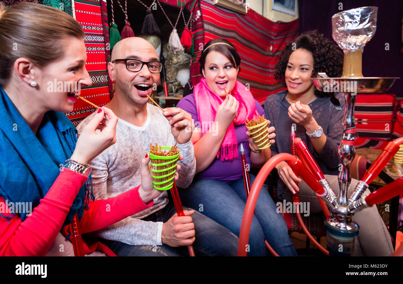 Women and man enjoying recreational shisha in hookah lounge Stock Photo ...