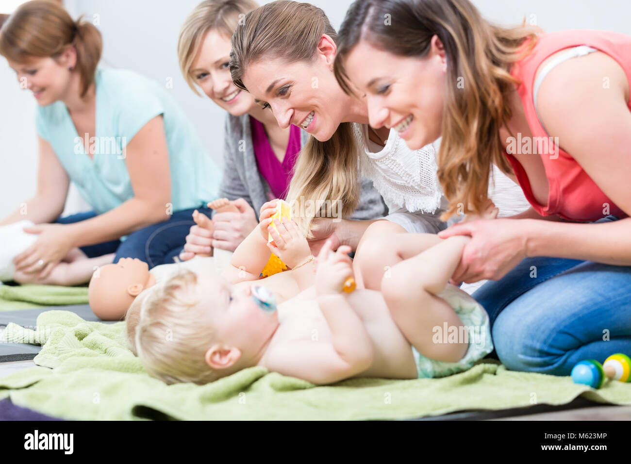 Group of cheerful women learning to take care of their babies Stock ...