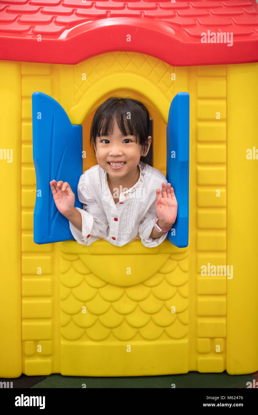Asian Chinese little girl playing in toy house at indoor playground ...