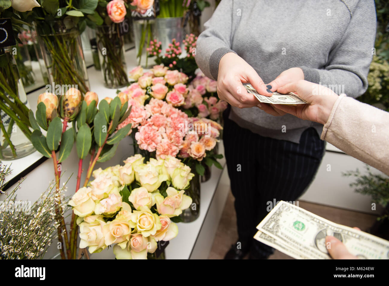 Woman get payment for bouquet in flower store Stock Photo - Alamy