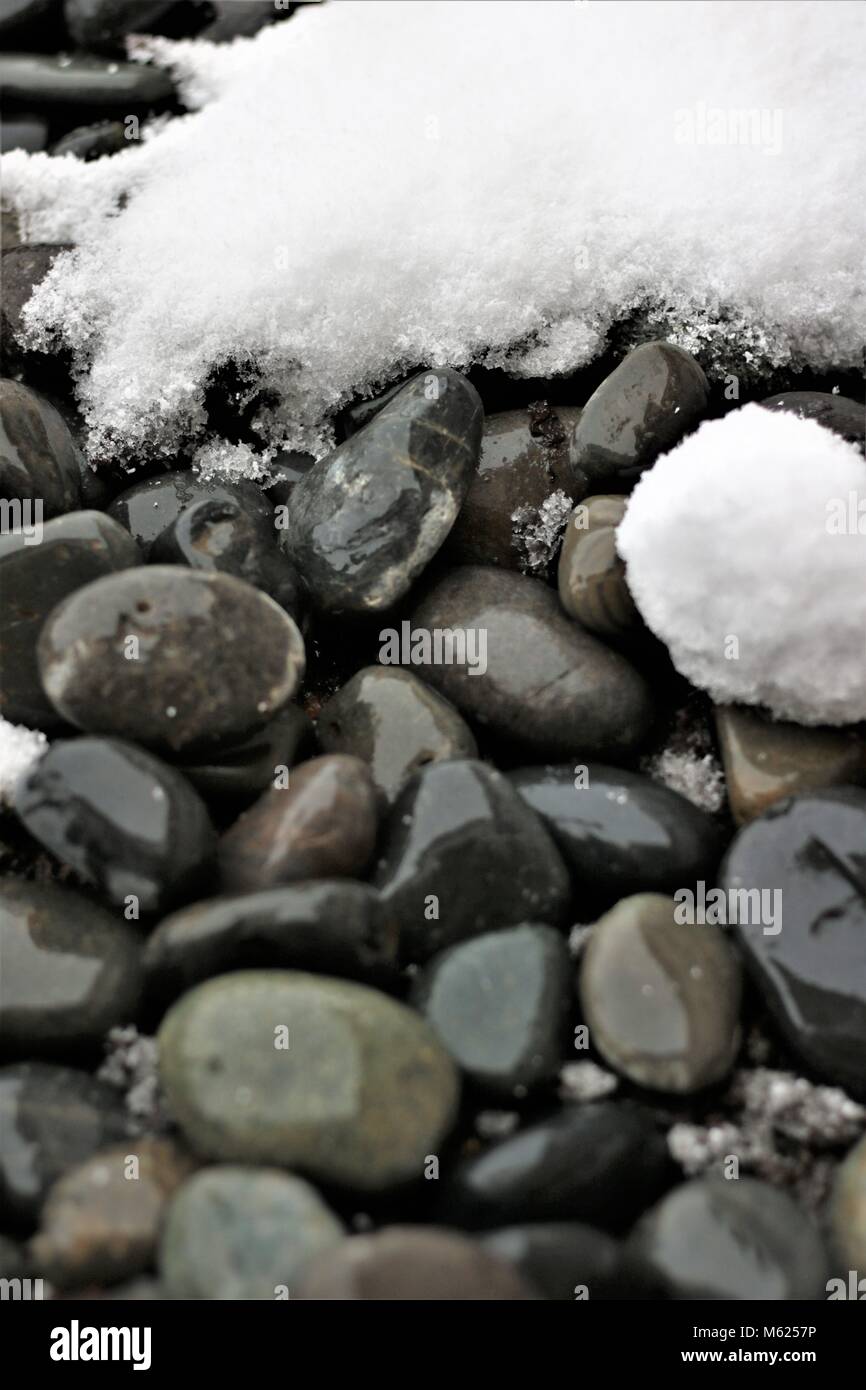 River Rock covered in Snow Stock Photo - Alamy