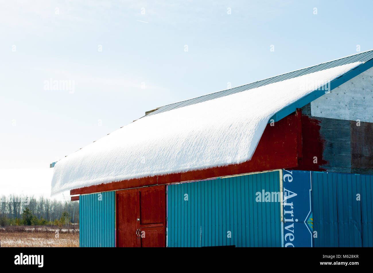 A sheet of ice sliding down from the roof of the barn Stock Photo - Alamy