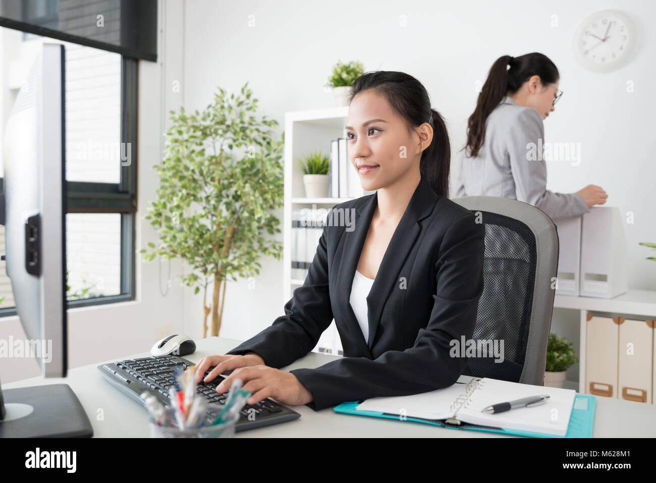 charming business lady working on computer and colleagues searching the ...