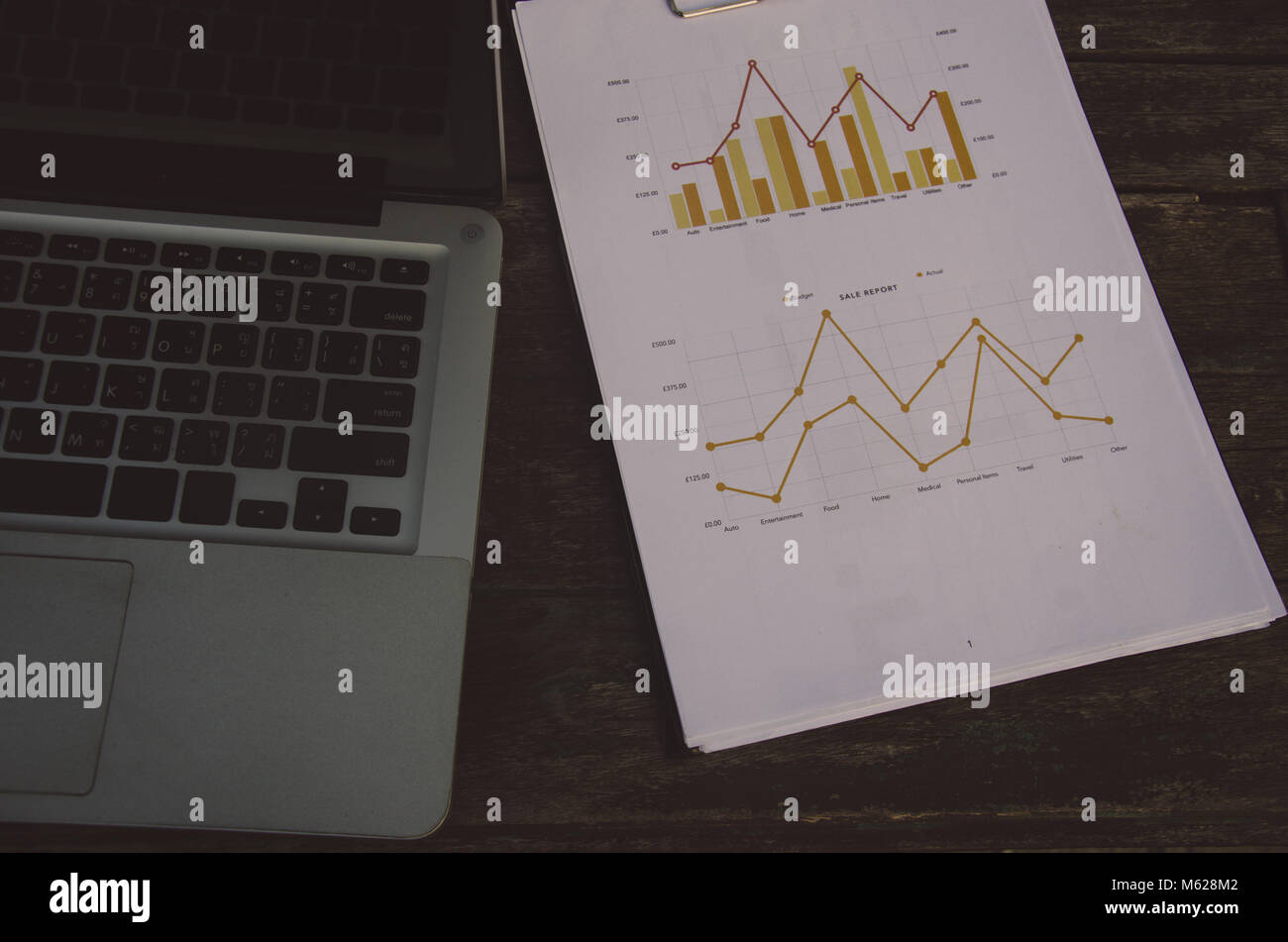 Financial chart with computer laptops on table woods Stock Photo - Alamy