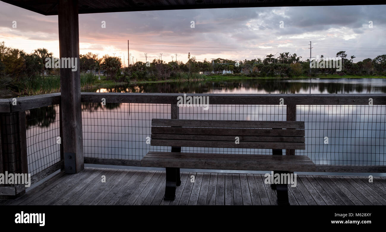 Sunset Wooden bench on a secluded, tranquil boardwalk along a marsh ...