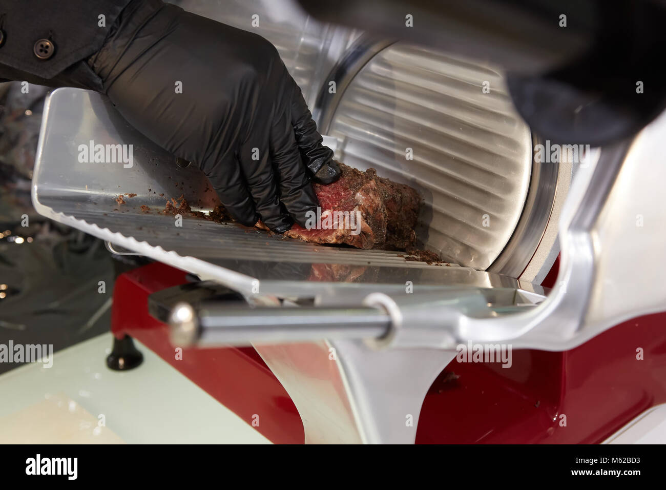 Man slicing meat with machine Stock Photo - Alamy