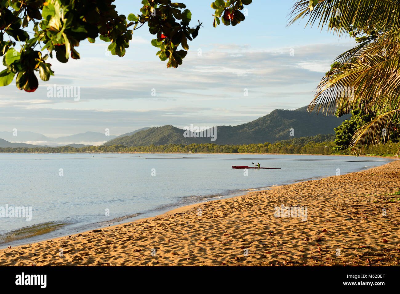Person setting out in a kayak at sunrise, Palm Cove, Cairns Northern ...