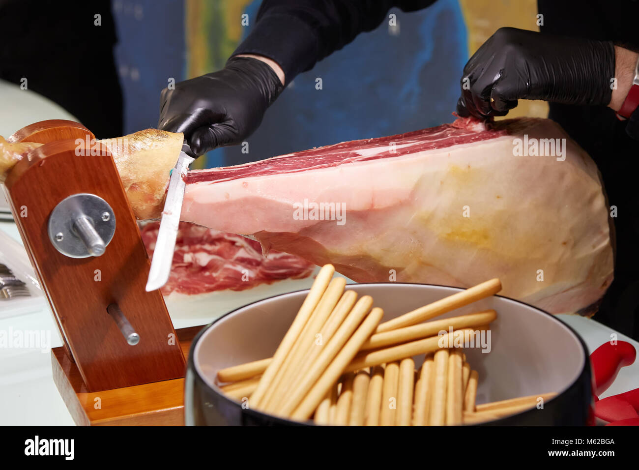 Sliced dried chamon prosciutto. A man cuts a jamon, a warm toned image ...