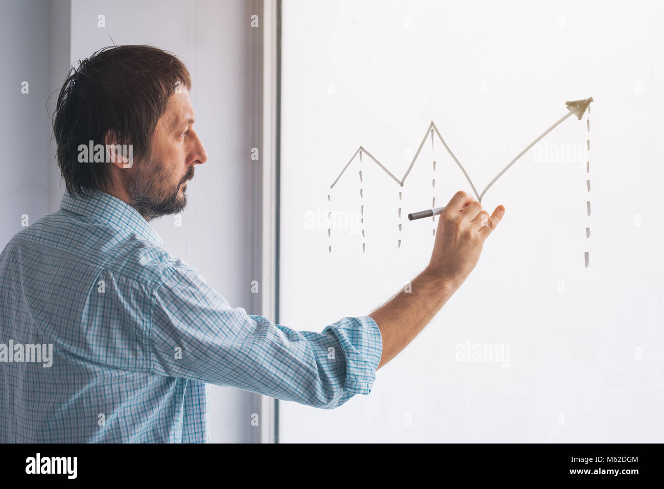 Businessman drawing rising linear diagram, conceptual symbol for profit ...