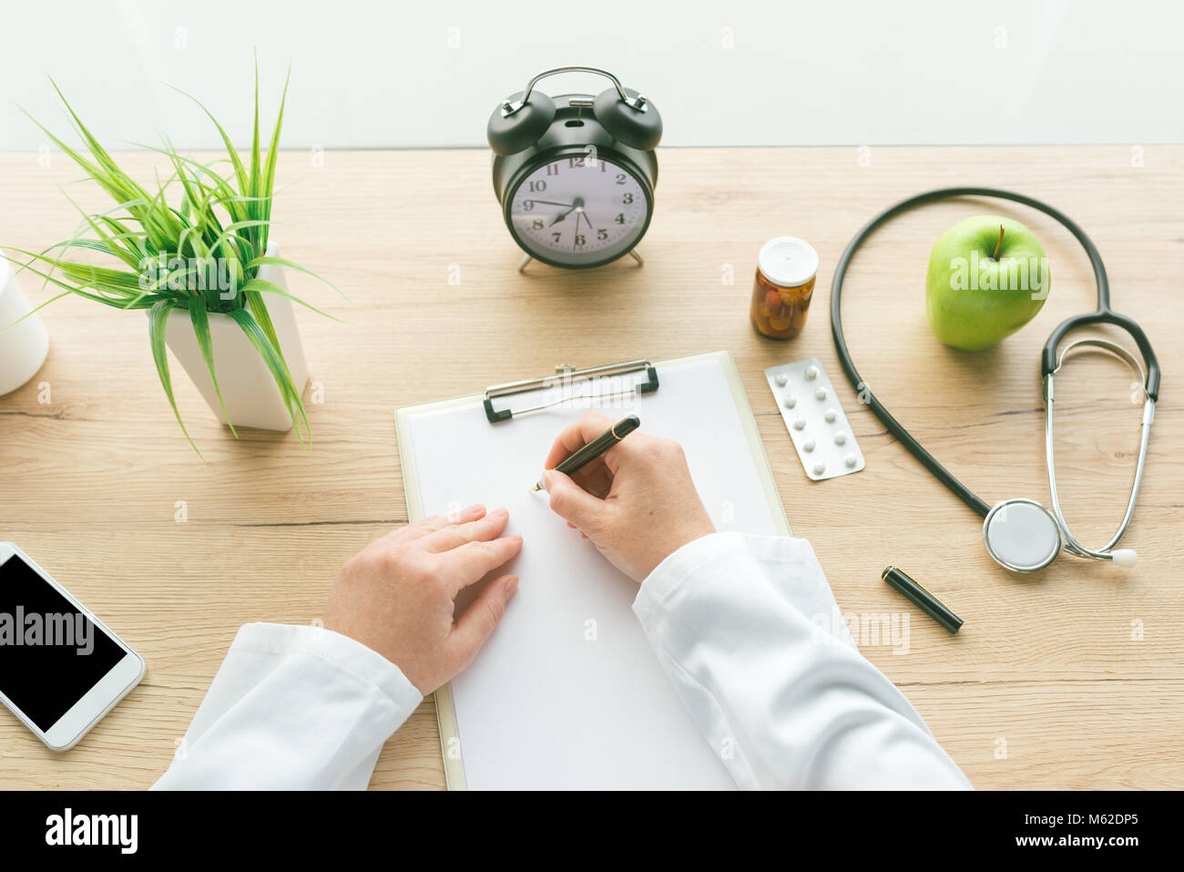 Female doctor writing notes, patient's medical history or medicine ...