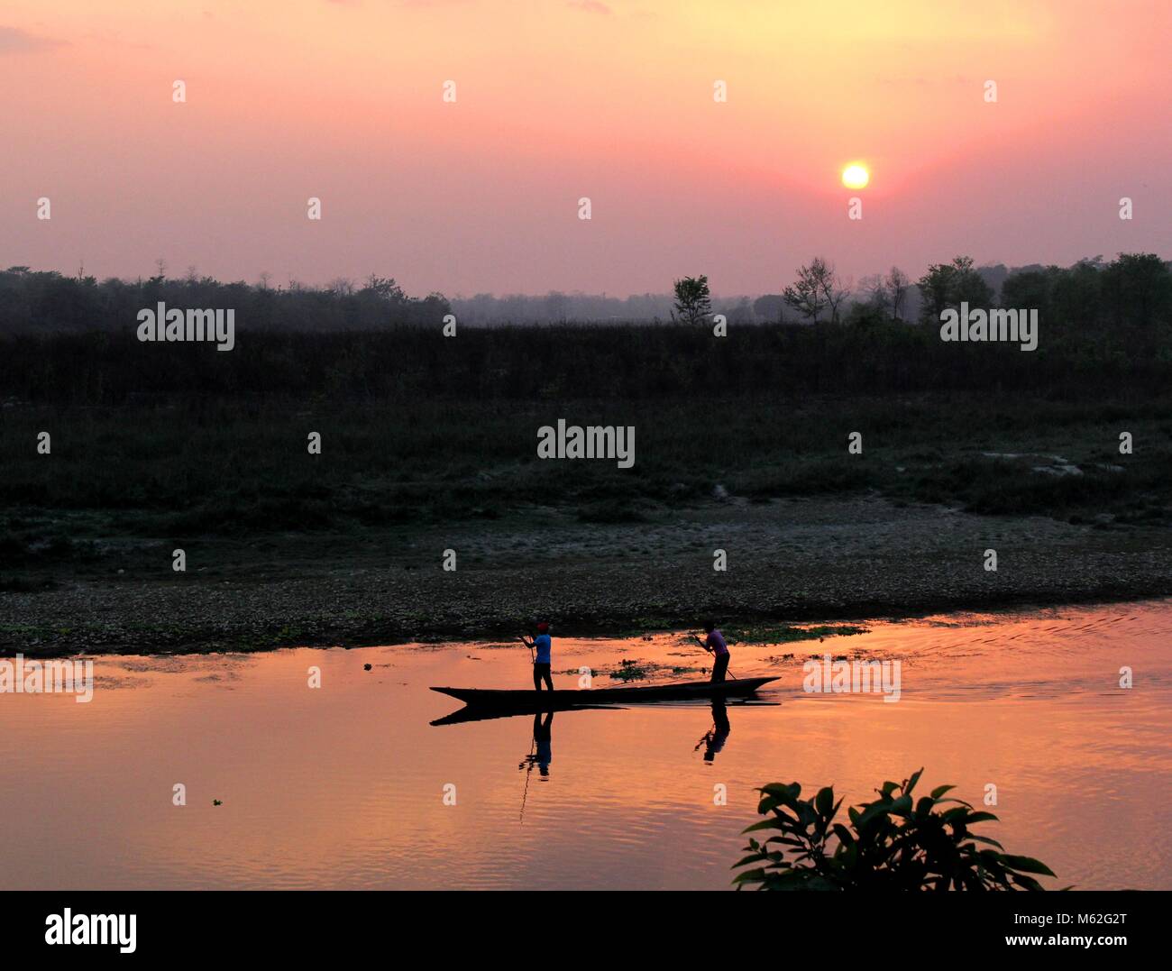 Sundown in Chitwan National Park Nepal, 2 men in a boat Stock Photo - Alamy