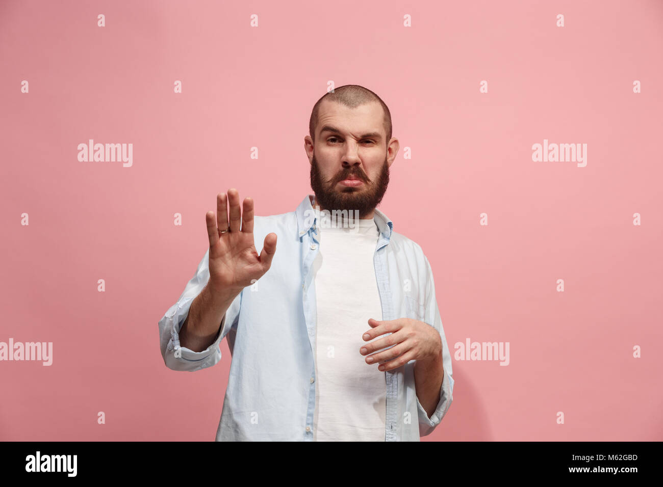 Young man with disgusted expression repulsing something, isolated on ...