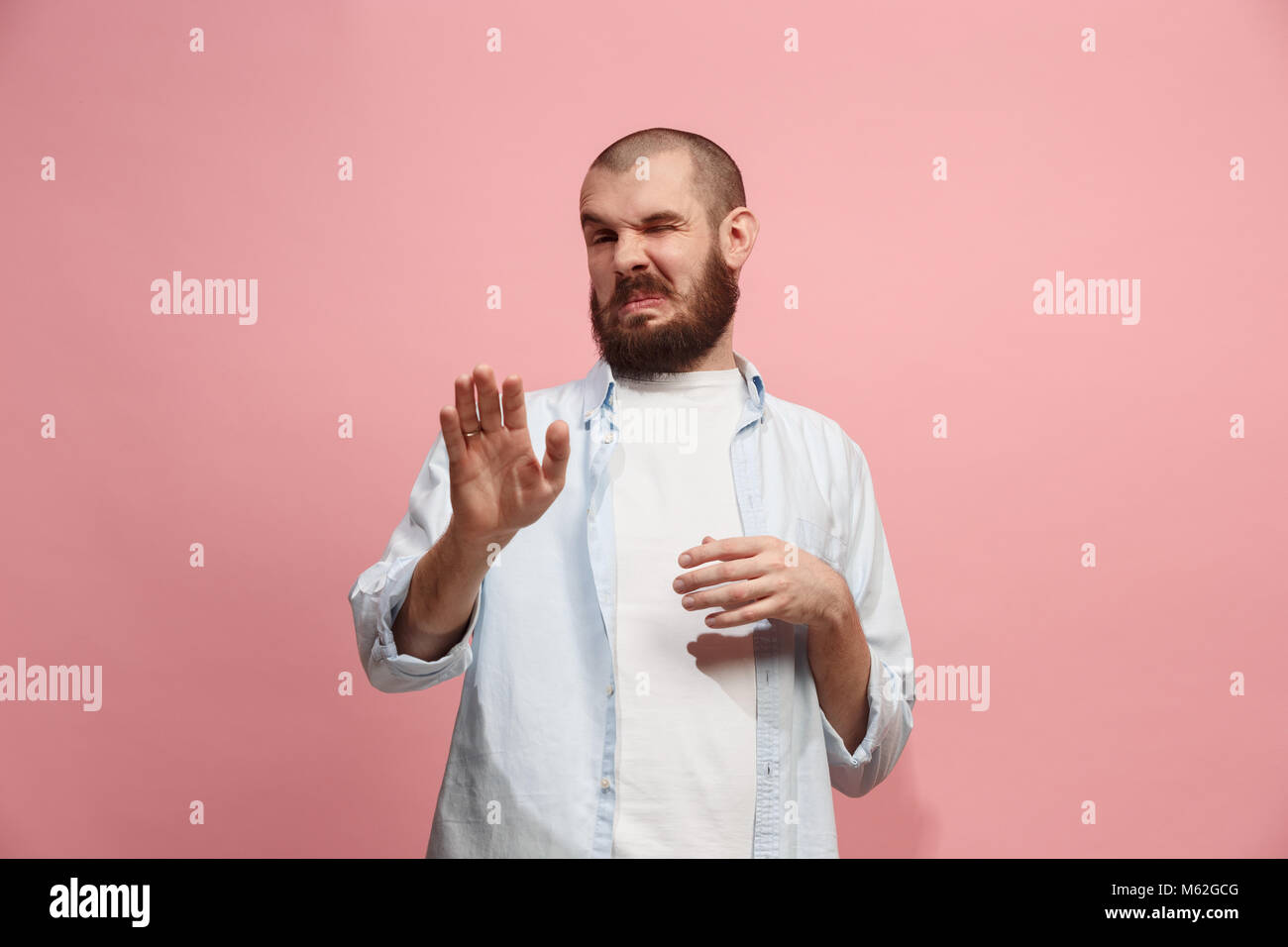 Young man with disgusted expression repulsing something, isolated on ...