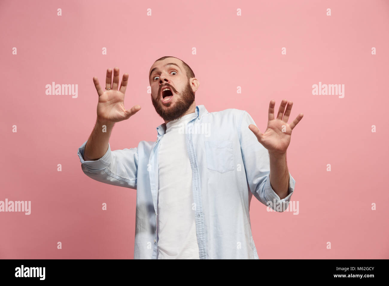 Portrait of the scared man on pink Stock Photo - Alamy