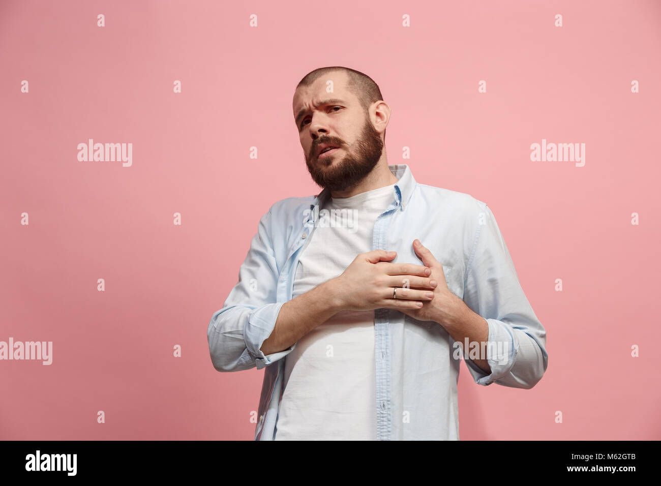 Man having heart pain. Isolated over pink background Stock Photo - Alamy