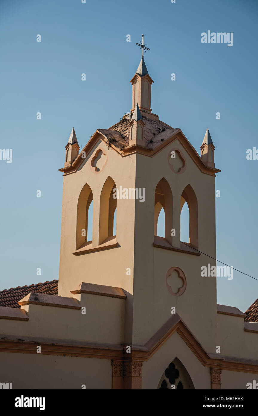 Small church facade and belfry with sunlight on one side and shadow on ...