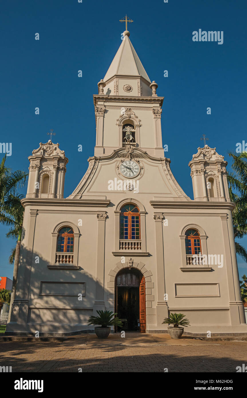 Church facade and belfry in front of a small cobblestone square with ...