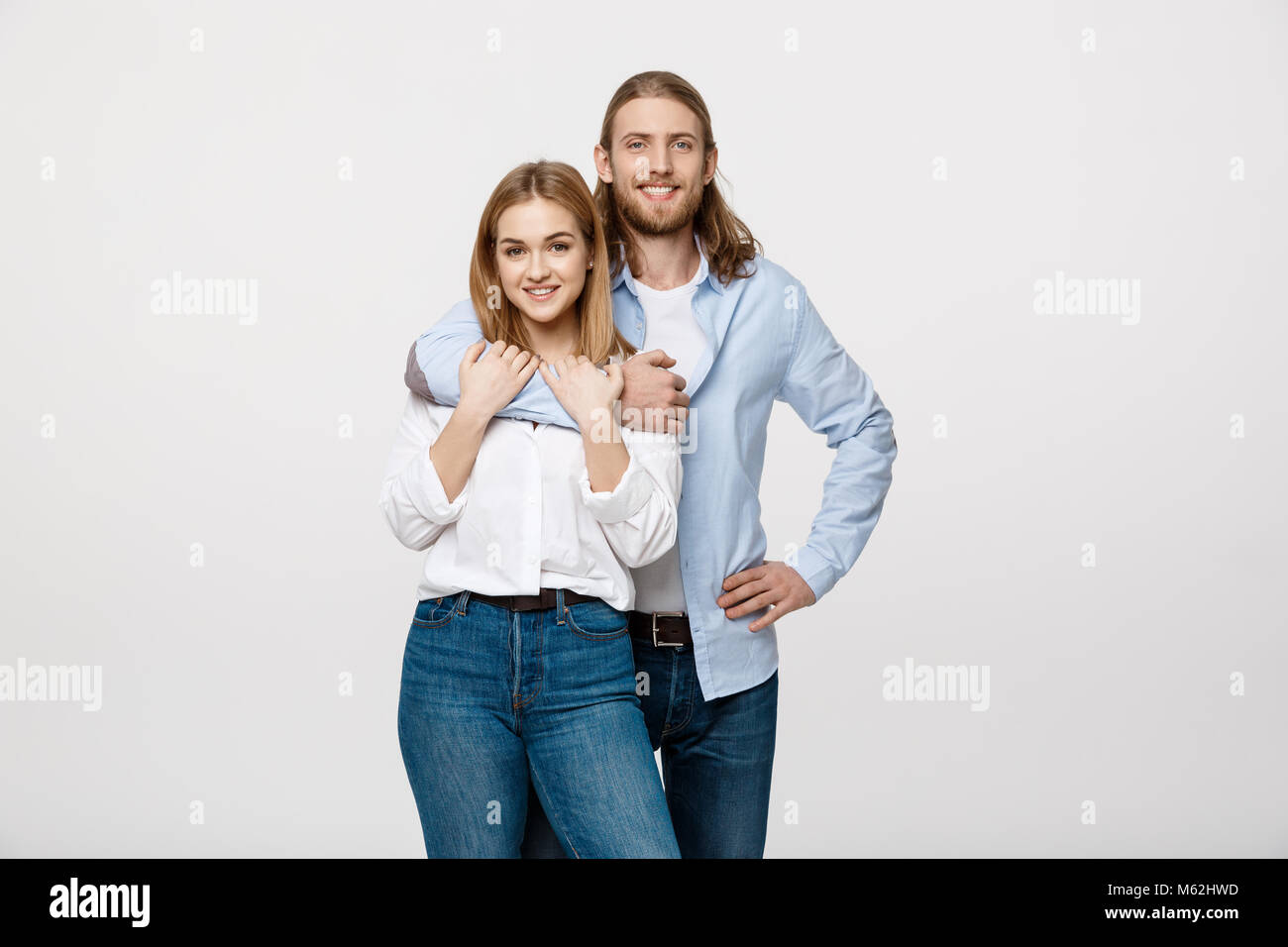 Portrait of cheerful young couple standing and hugging each other on ...