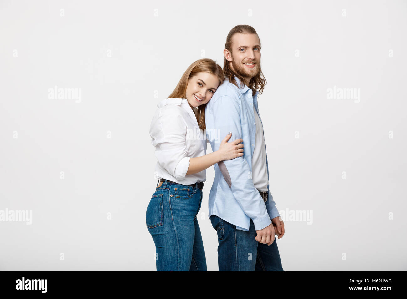 Portrait of cheerful young couple standing and hugging each other on ...