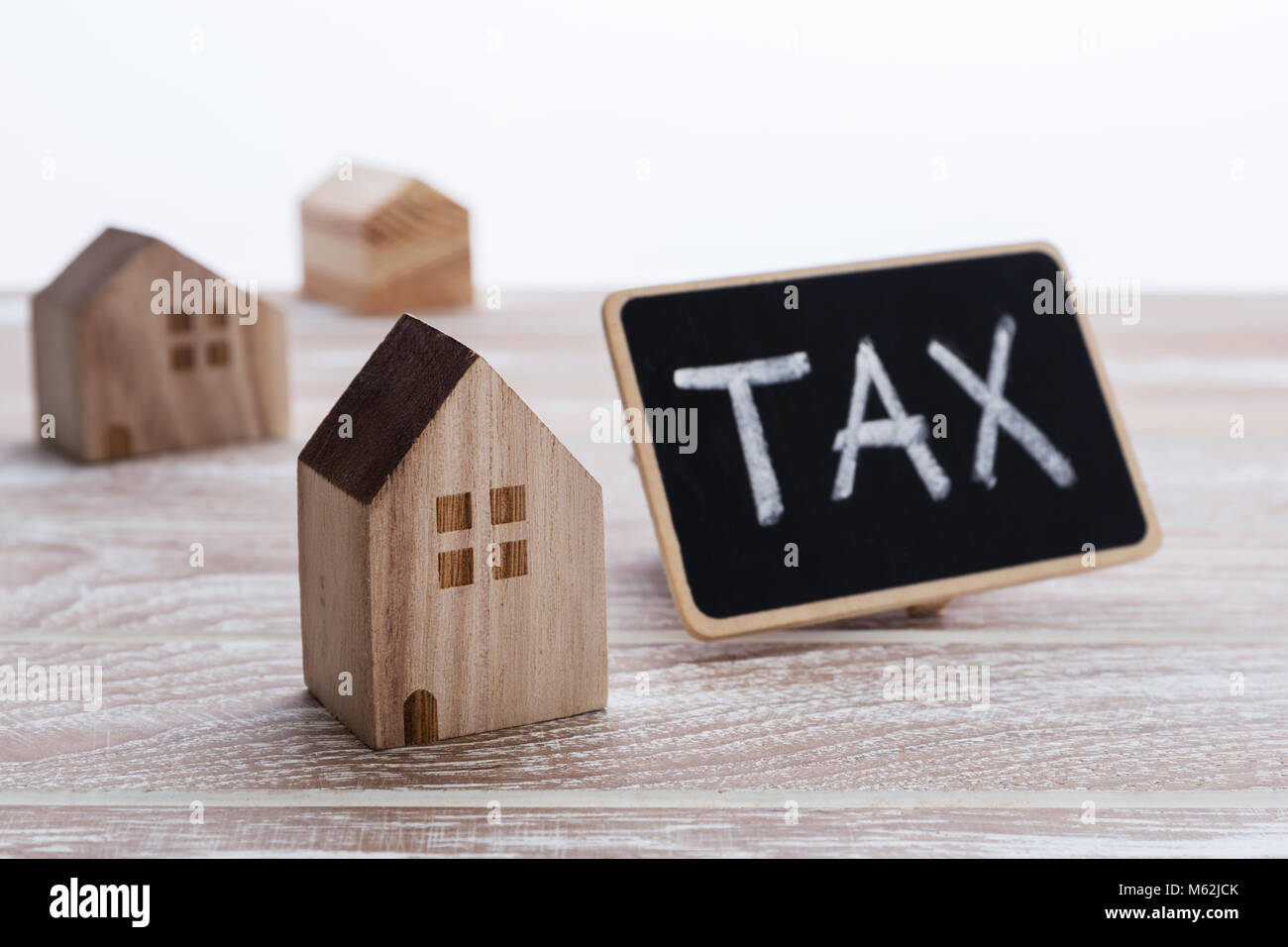 Property tax concept with model of houses with tax sign on wooden table ...