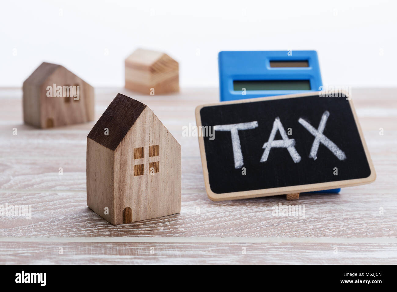 Property tax concept with house model and tax sign on wooden table ...