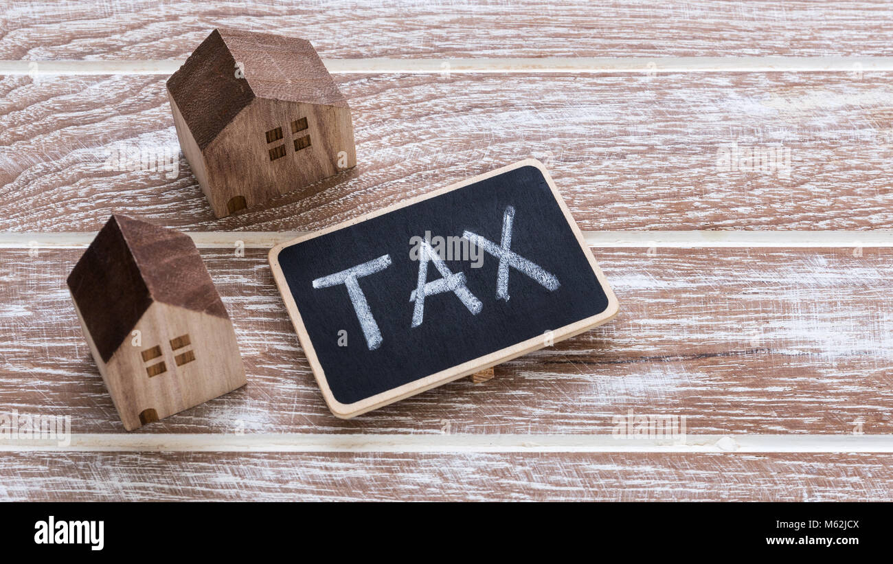 Tax sign and house model on wooden table background Stock Photo - Alamy