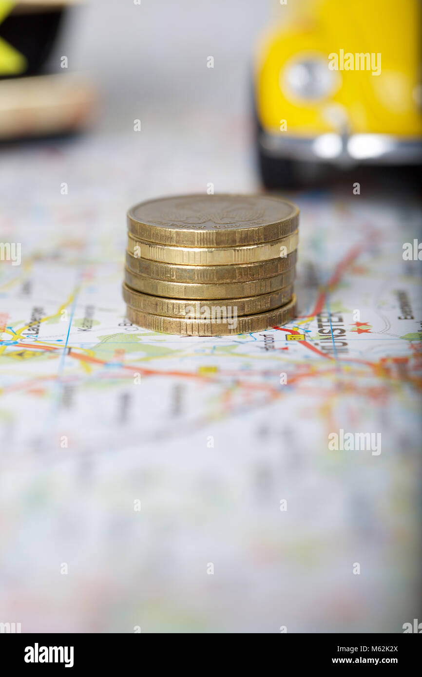 Coins on a map. Mini car in the background. Closeup Stock Photo - Alamy