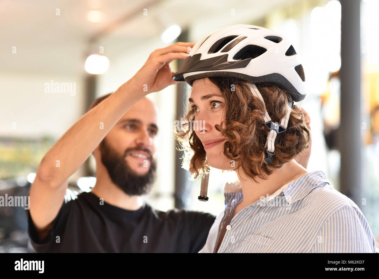 Bicycle shop consulting - customer tests a bicycle helmet for road ...