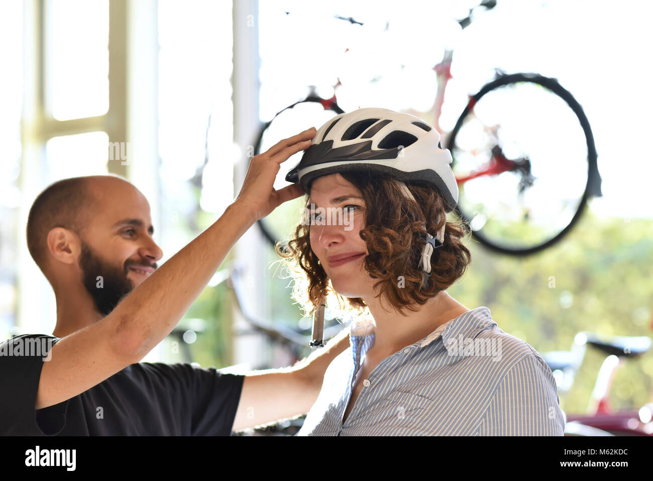 Bicycle shop consulting - customer tests a bicycle helmet for road ...