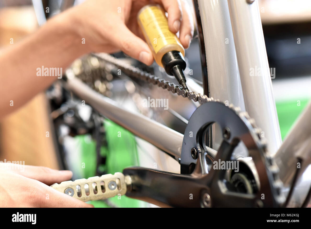 mechanic in a bicycle repair shop oiling the chain of a bike Stock ...