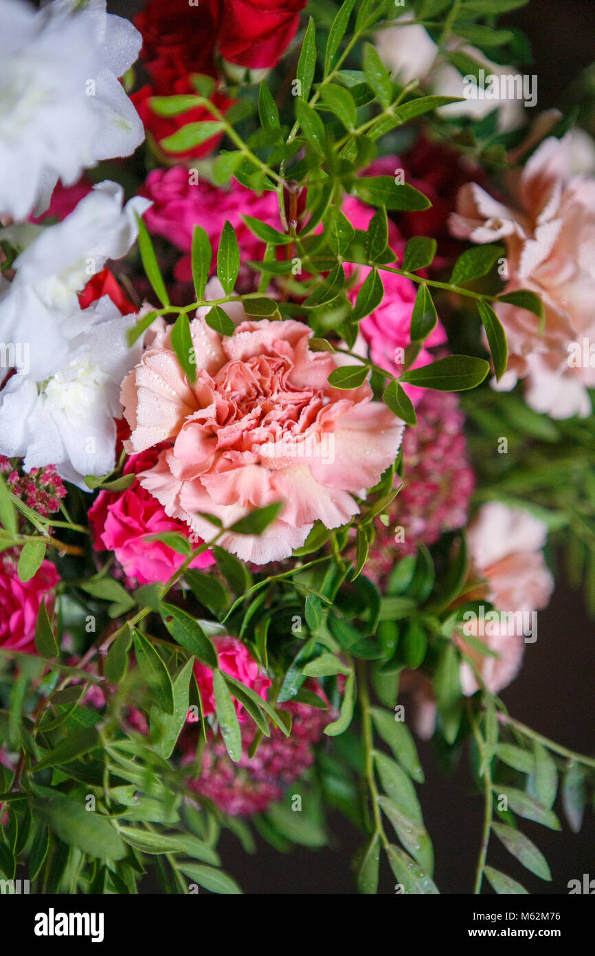 High bouquet in a shiny vase of delphinium, roses and carnations in a ...