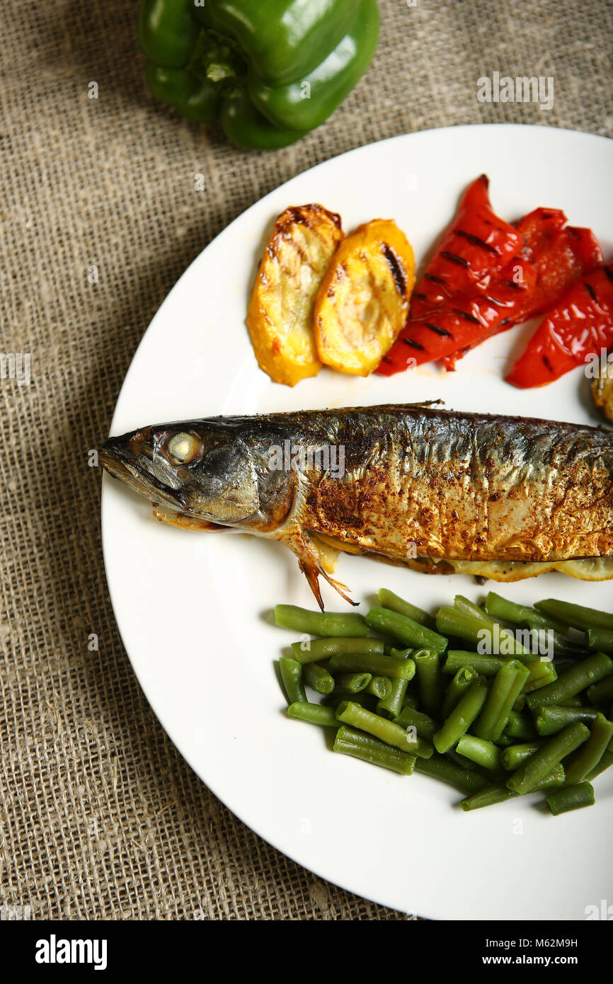 Healthy and proper food, grilled fish and vegetables with lemon and ...