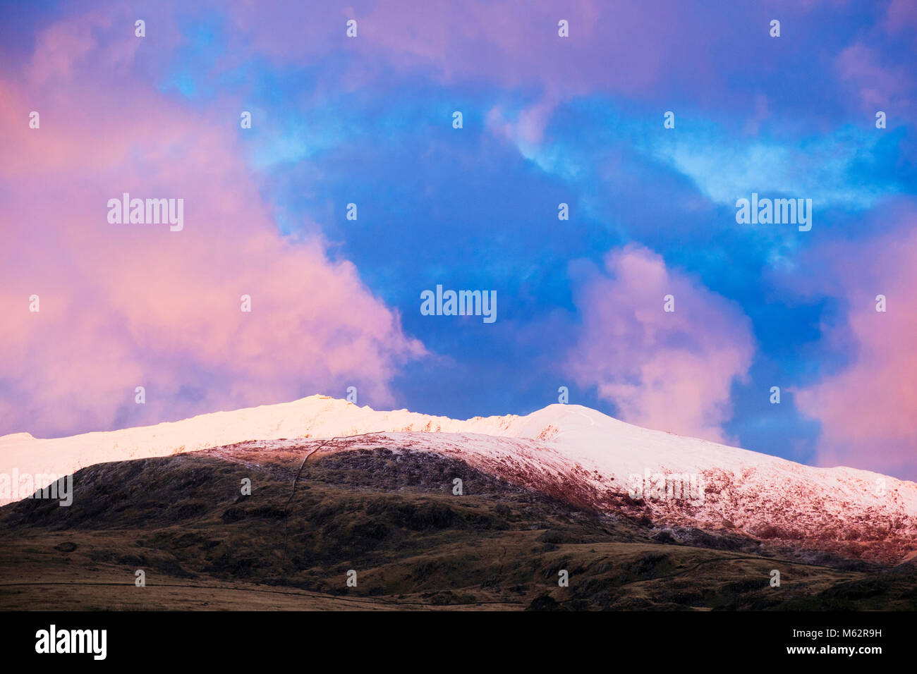 Pink clouds at sunset above snow capped Mt Snowdon and south ridge in ...