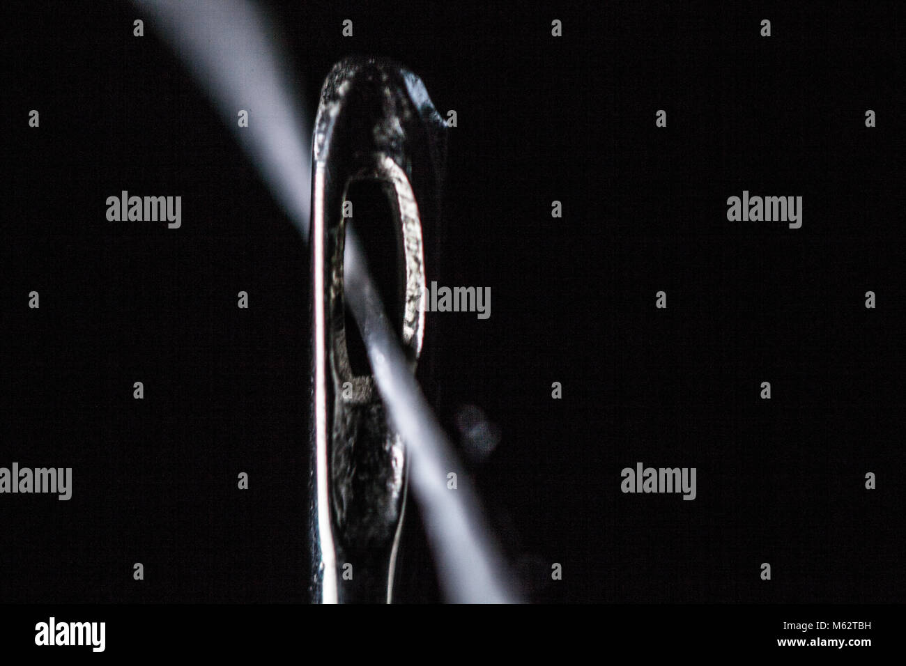 Macro close up thread through of eye of needle in black and white Stock ...