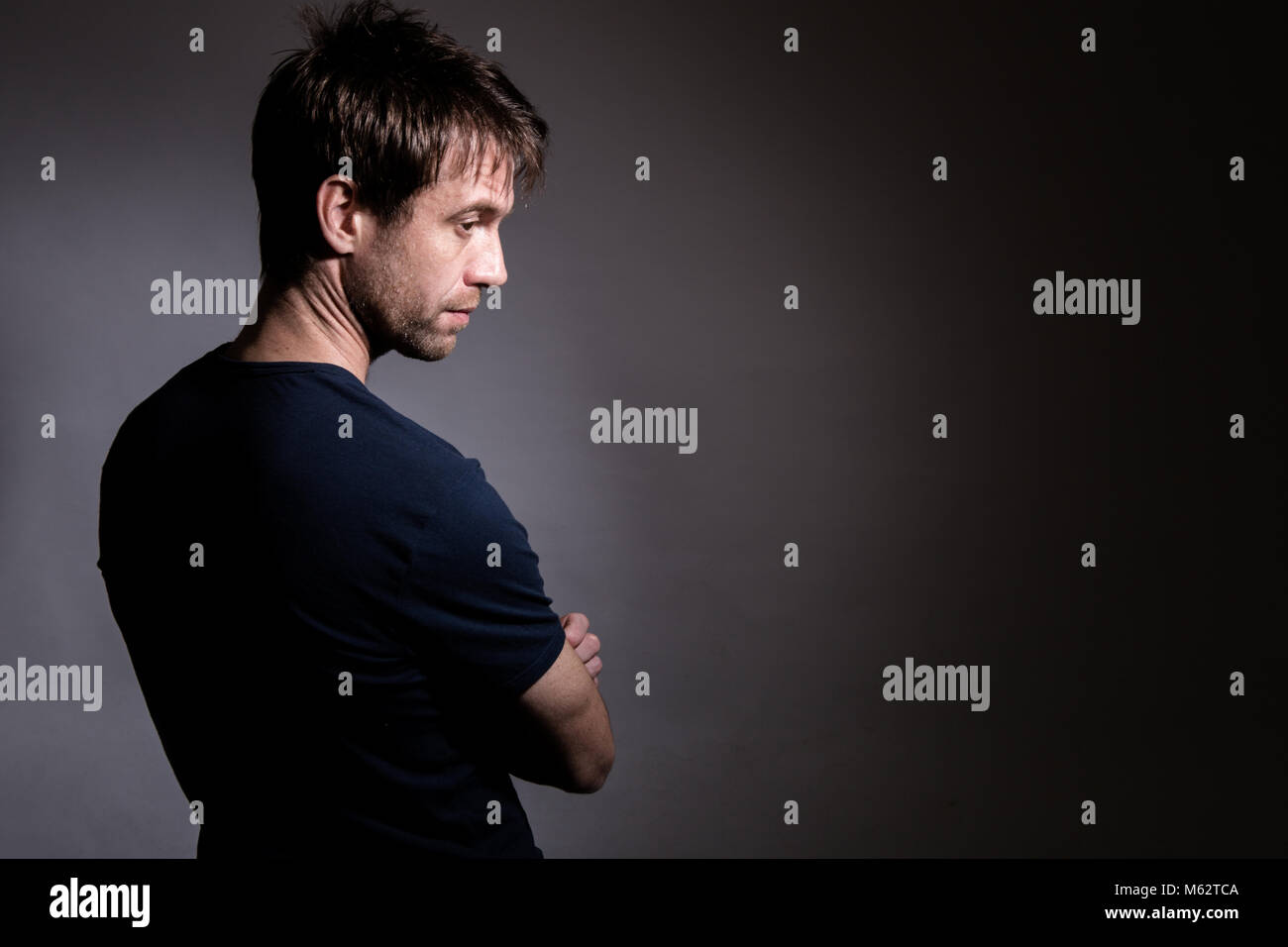 Young white male with back to camera looking down with thoughtful ...