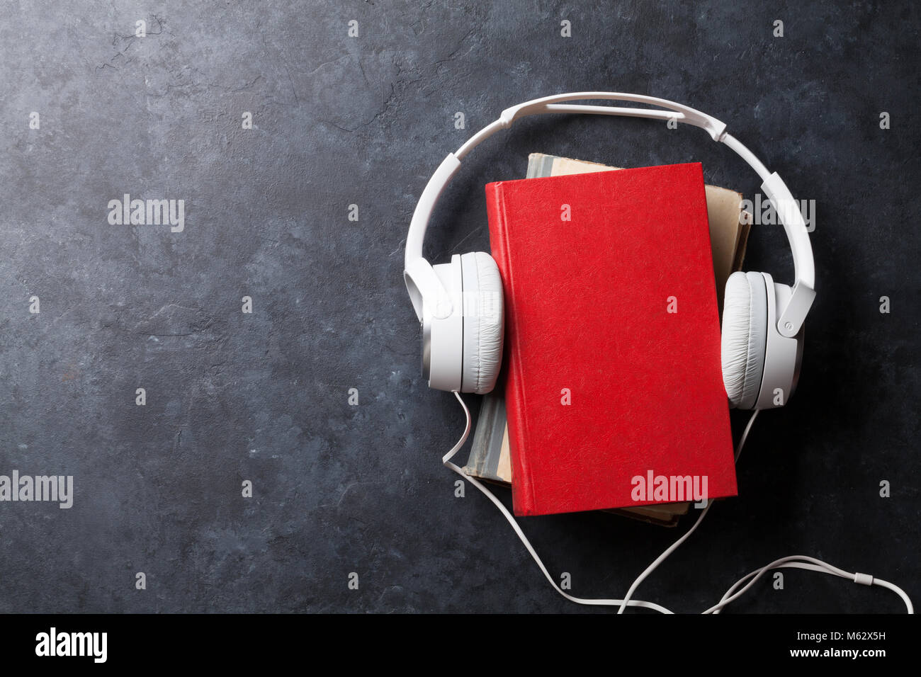 Audio book concept. Headphones and books over stone table. Top view ...