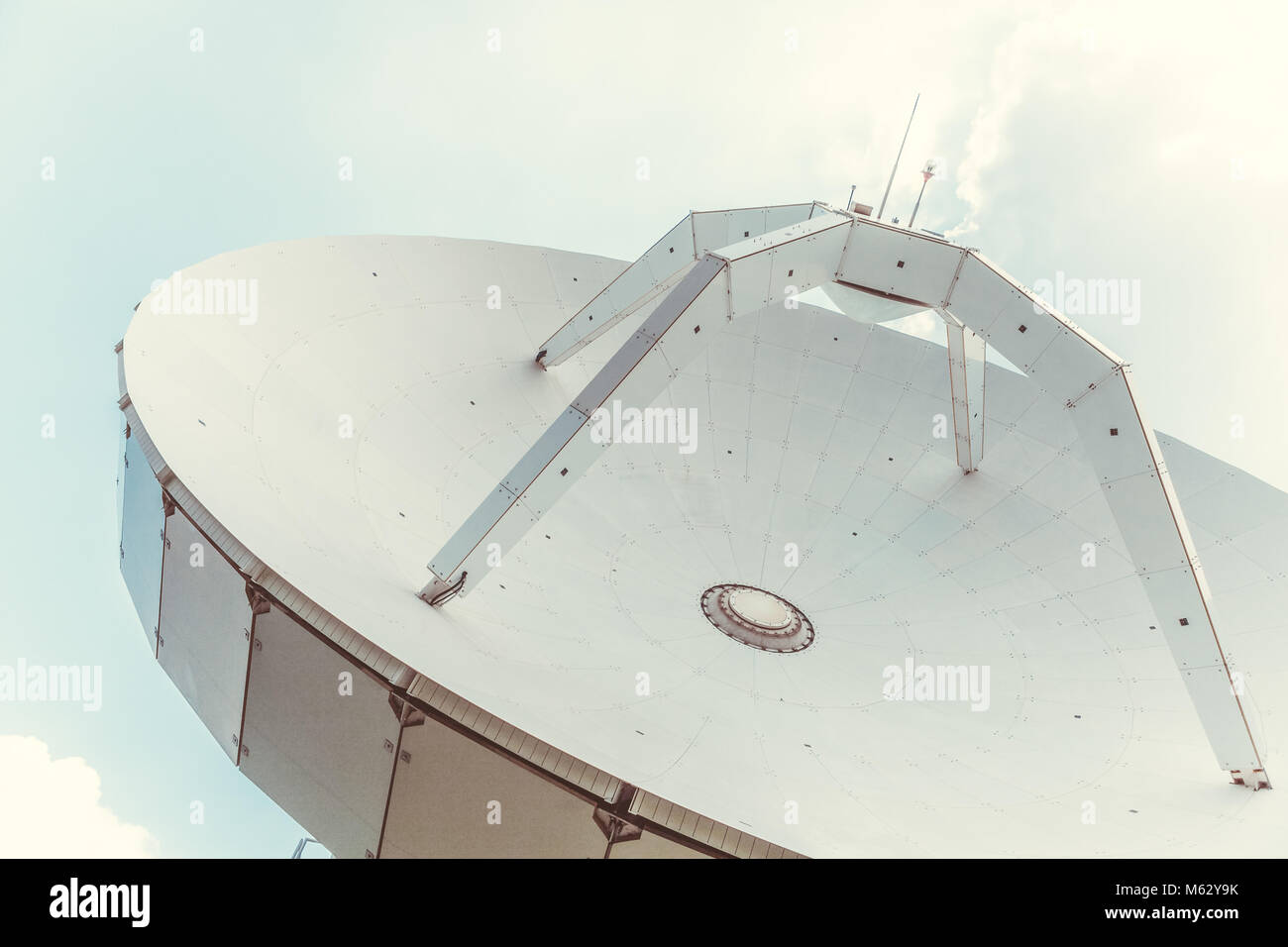 Big parabolic antenna at a daytime with clear clue sky on background ...